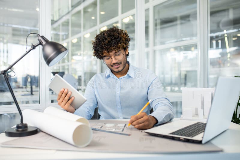 Architect Reviewing Blueprints and Models in Office Setting Stock Photo ...