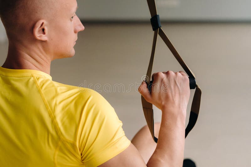 A Focused Male Athlete Performing an Exercise on Functional Loops in ...
