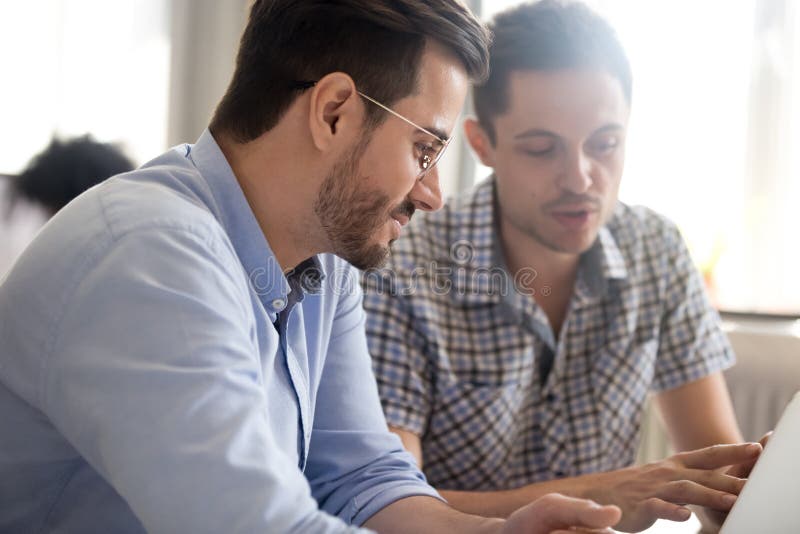 Focused Male Colleagues Work Together Using Laptop Discussing on Stock ...
