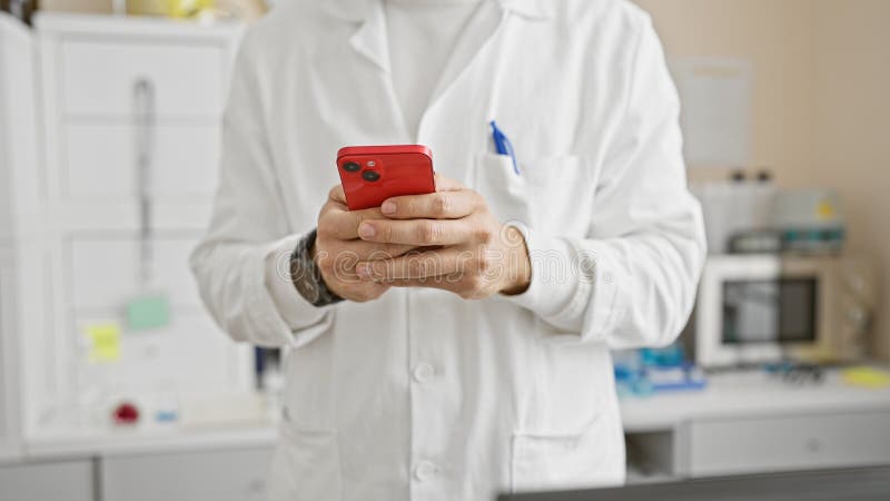 A Focused Male Healthcare Professional Using a Smartphone in a ...