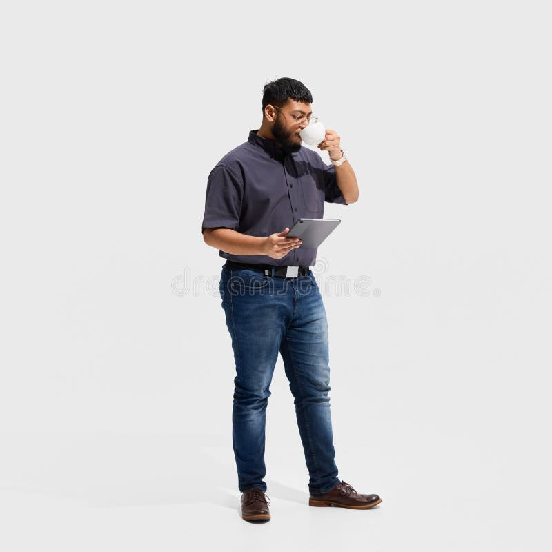 Focused Male Professional Sipping Coffee while Reading Tablet ...