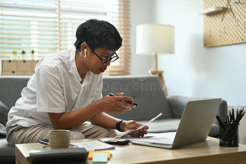 Focused Asian Man Calculating Household Expenses Expenditures, Make ...