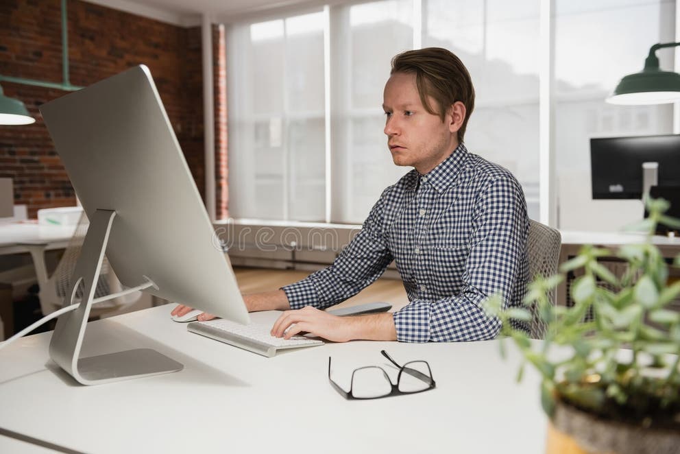 Focused Man Working on Desktop Computer in Modern Office Environment ...