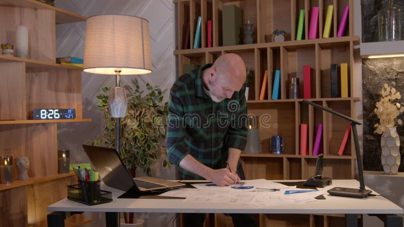 Focused Mature Man Architect Working and Drawing Blueprint with ...