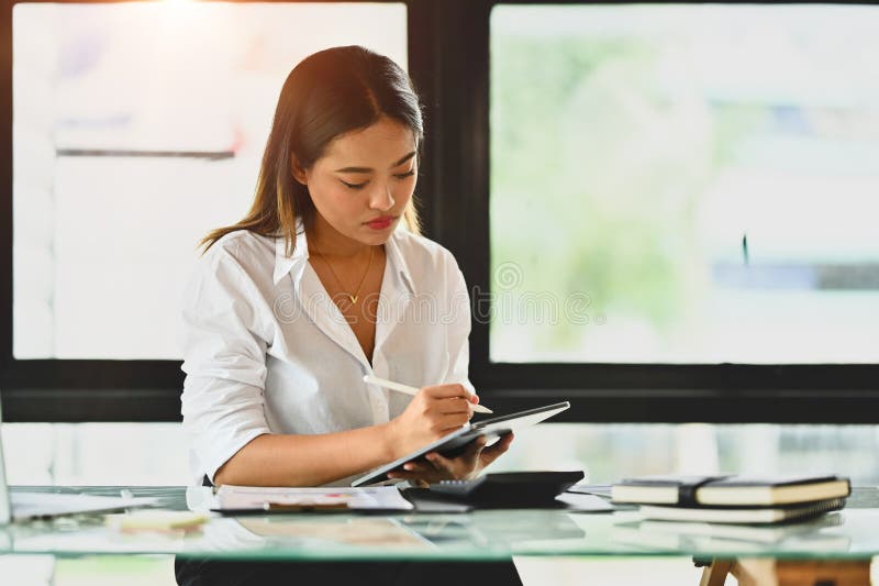 Focused Millennial Female Manager Using Digital Tablet and Analyzing ...