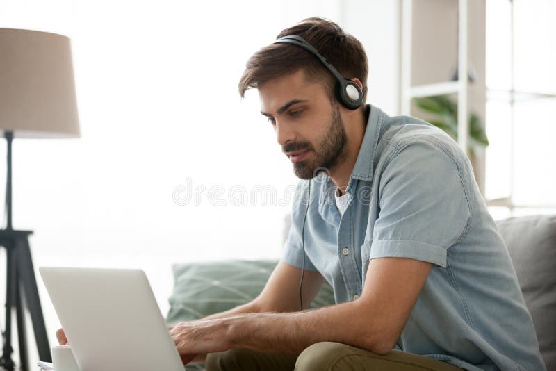 Focused Millennial Man in Headset Using Computer Online Stock Photo ...