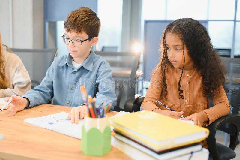 Focused Multiracial Students Kids Writing Down Data into Notebook while ...