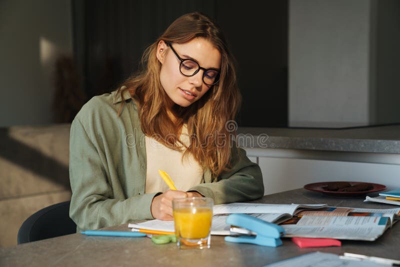 Focused Nice Student Woman Doing Homework while Sitting at Table Stock ...