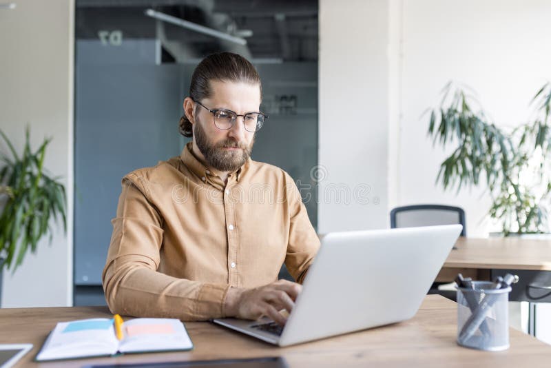 Professional Man Working on a Laptop in a Modern Office Setting Stock ...