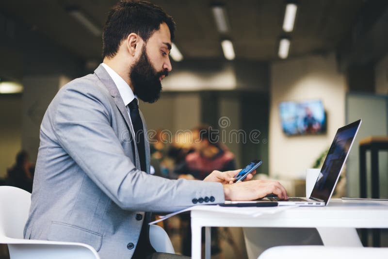Focused Office Worker Using Laptop and Smartphone Stock Photo - Image ...