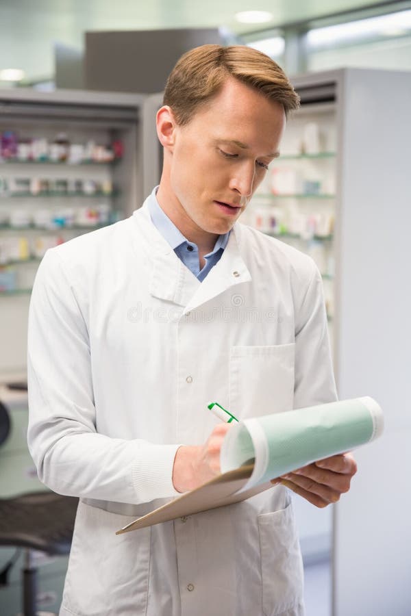 Focused Pharmacist Writing on Clipboard Stock Image - Image of ...