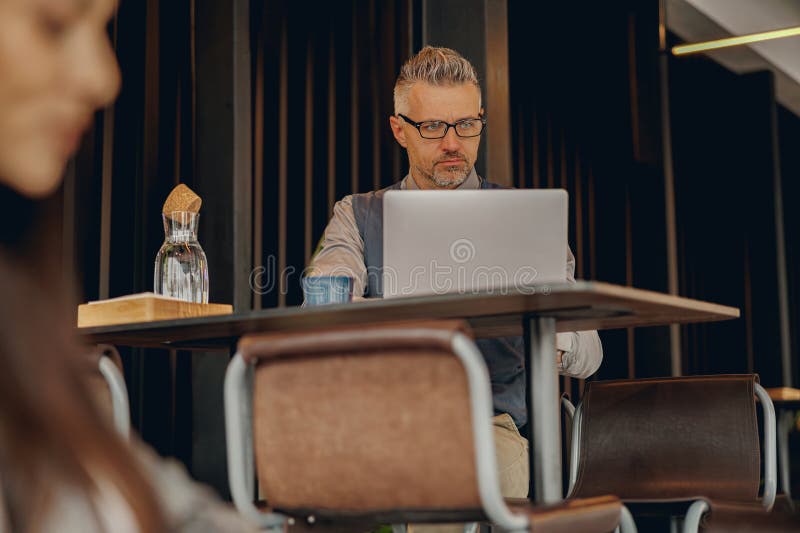 A Focused Professional Engaged in Work on a Laptop within a Modern and ...