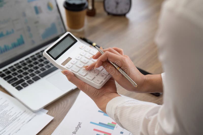 Focused Professional Using Calculator for Financial Analysis and ...