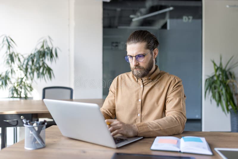Businessman Working on Laptop Computer in Modern Office Environment ...