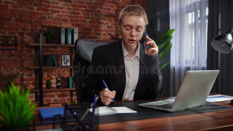 Focused Professional Writing Notes in Modern Office and Talking on ...