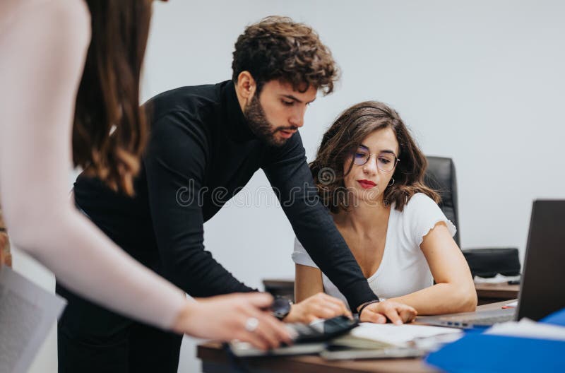 Two Professionals Collaborating at a Desk with a Laptop in a Modern ...