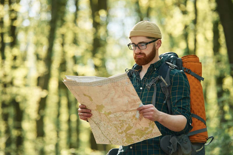 Focused on Reading the Map. Bearded Man is in the Forest at Daytime ...
