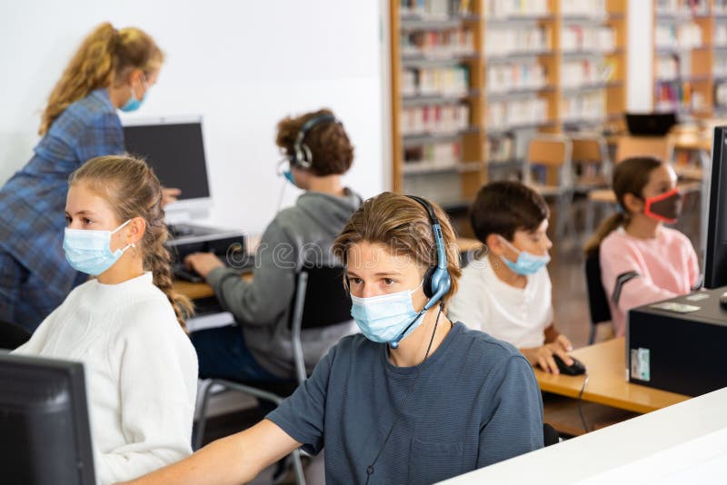 Focused Schoolchildren in Masks at the Computer Stock Photo - Image of ...