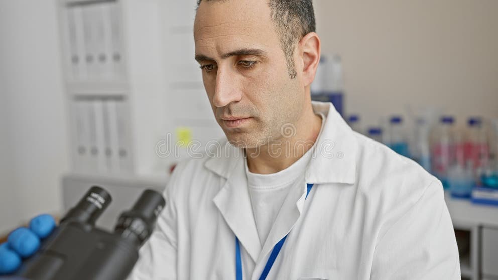 Focused Scientist Man in Lab Coat Analyzing Specimen with Microscope in ...