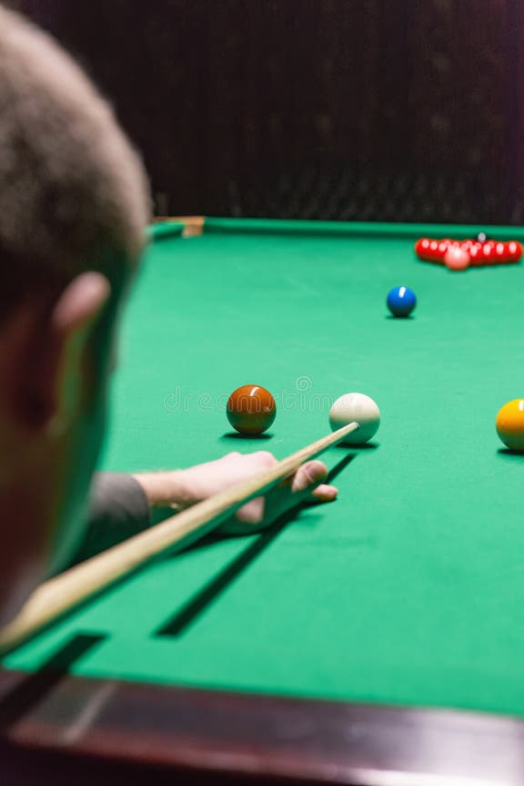 A Focused Snooker Player Demonstrating Skill and Precision during a ...