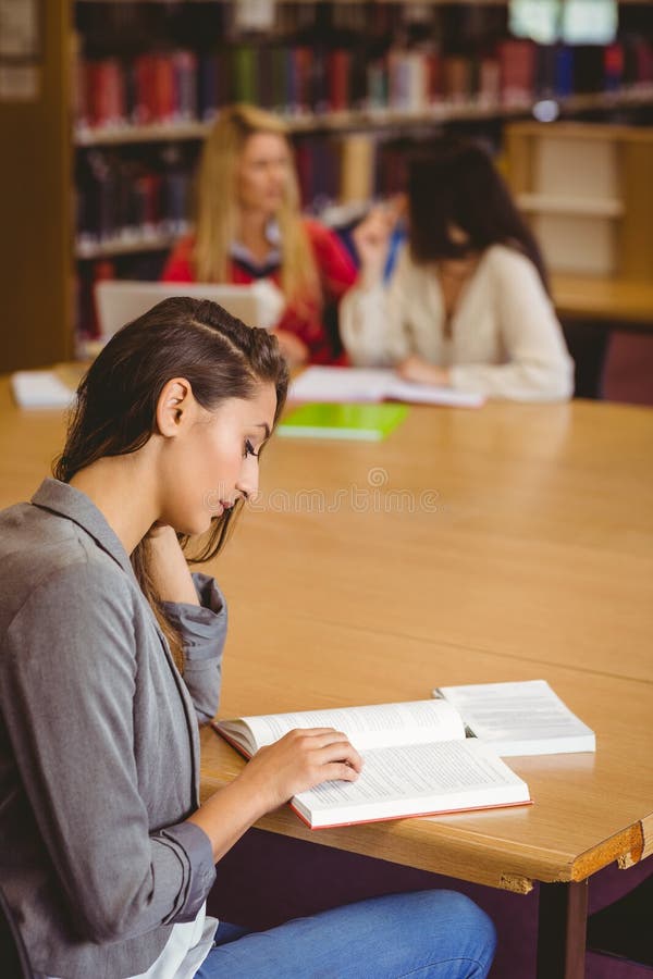 Focused Student Sitting at Desk Reading Text Book Stock Image - Image ...