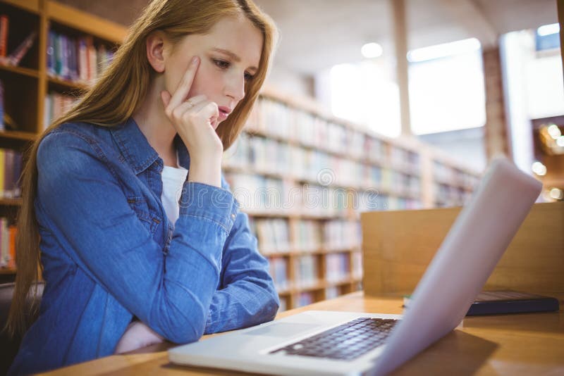 Focused Student Using Laptop in Library Stock Photo - Image of female ...