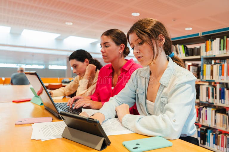 Focused Students Engaged in Collaborative Learning while Using Laptops and Tablets in a Library ...