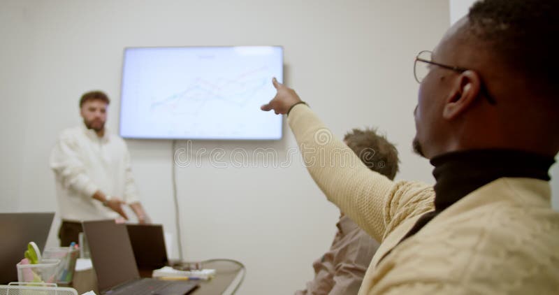 Engaged Multicultural Colleagues Discussing Growth Charts in a Modern ...