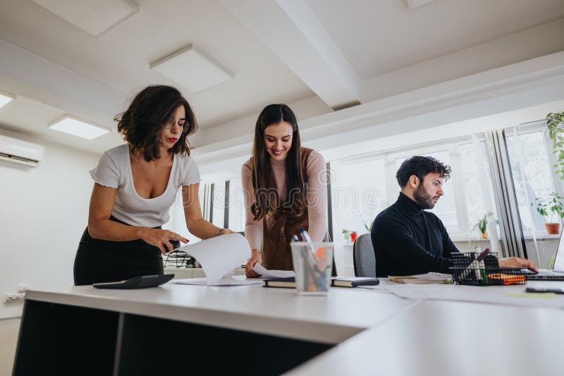 Focused Team at Work in a Modern Office: Two Women Collaborating and a ...