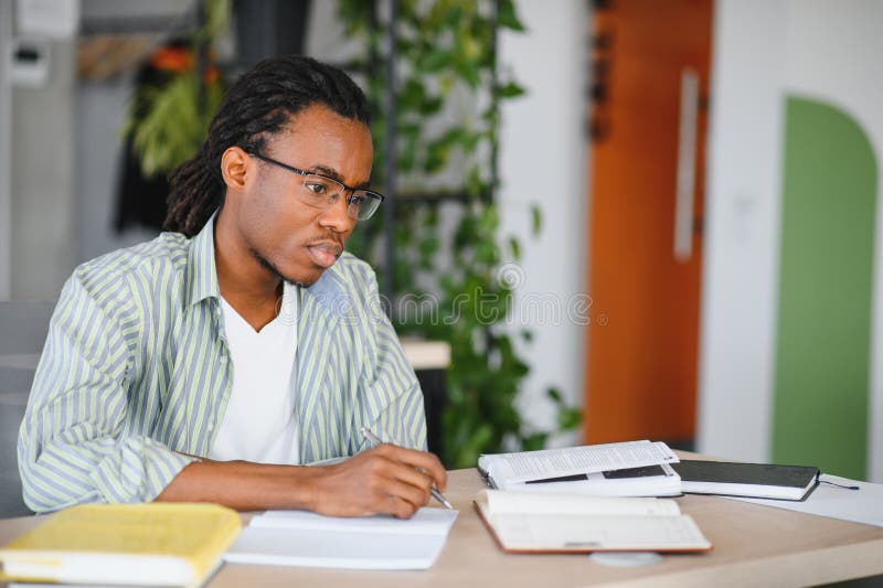 Focused University Student Studying and Taking Notes in Library Stock ...