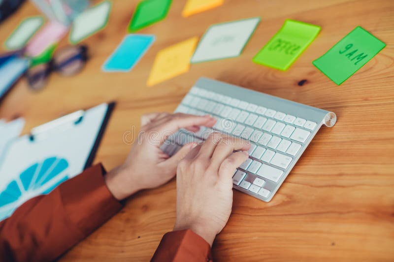 Modern Office Workspace with Hands Typing on a Keyboard Surrounded by ...