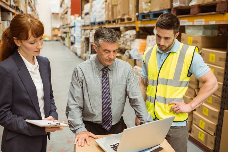 Focused Warehouse Team Working Together on Laptop Stock Image - Image ...