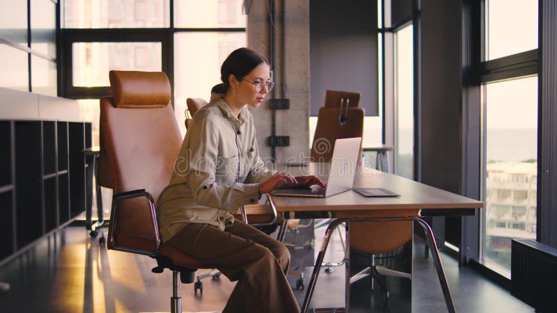 A Focused Woman Deeply Immersed in Her Work on a Computer in a Stylish ...