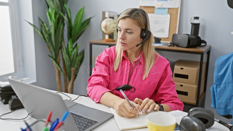 A Focused Woman with a Headset Working in a Modern Office Environment ...