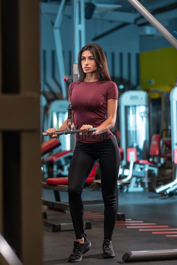 Woman Engaging in Strength Training with Cable Machine in Modern Gym ...