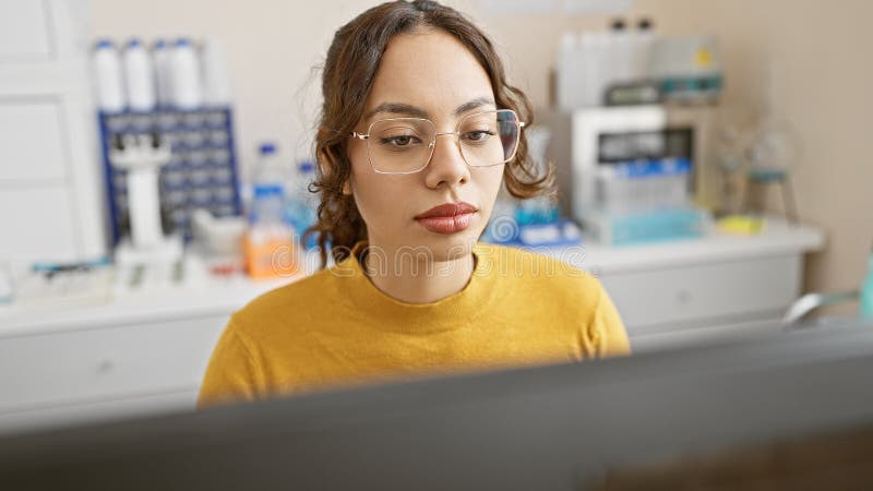 Focused Woman Wearing Glasses Analyzing Data in a Modern Laboratory ...