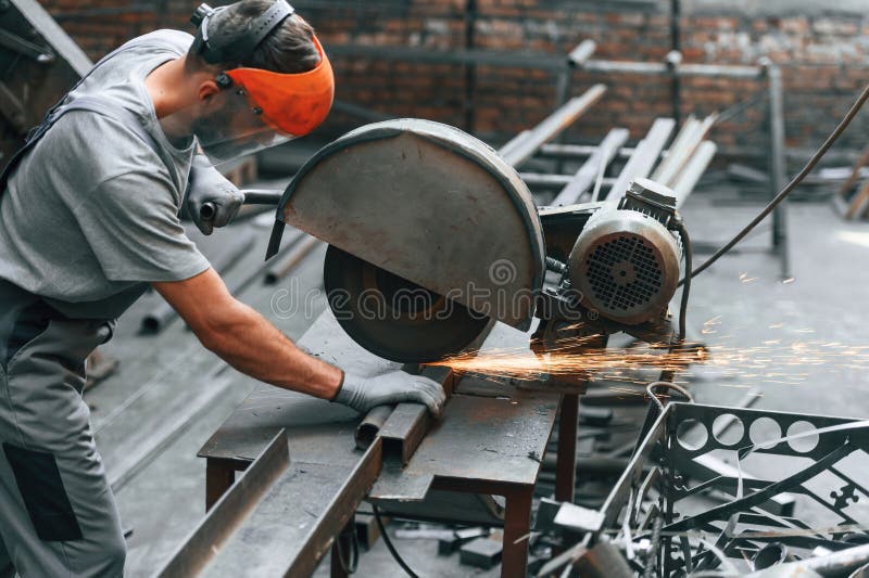 Focused at Work, Cutting the Metal. Young Man at Factory in Grey ...