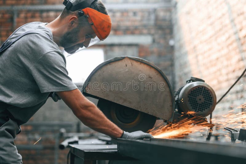 Focused at Work, Cutting the Metal. Young Man at Factory in Grey ...