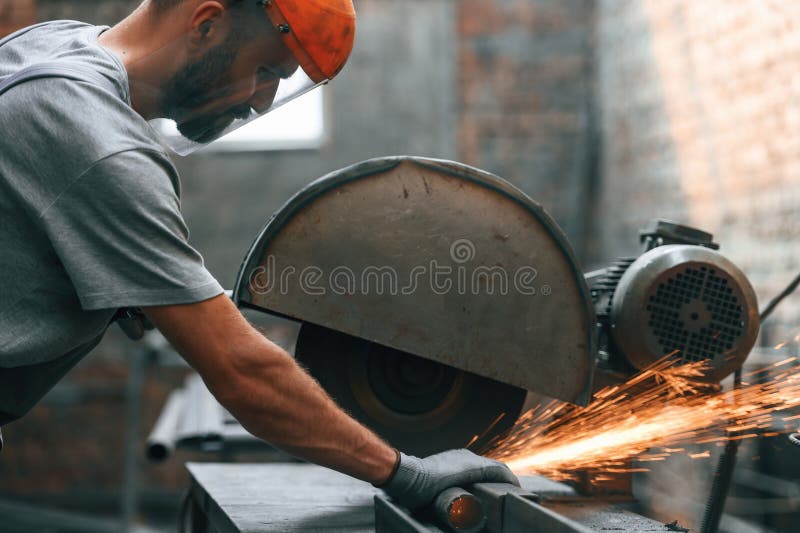 Focused at Work, Cutting the Metal. Young Man at Factory in Grey ...