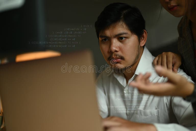 Focused Young Colleagues Analyzing Computer Code on Monitor while ...