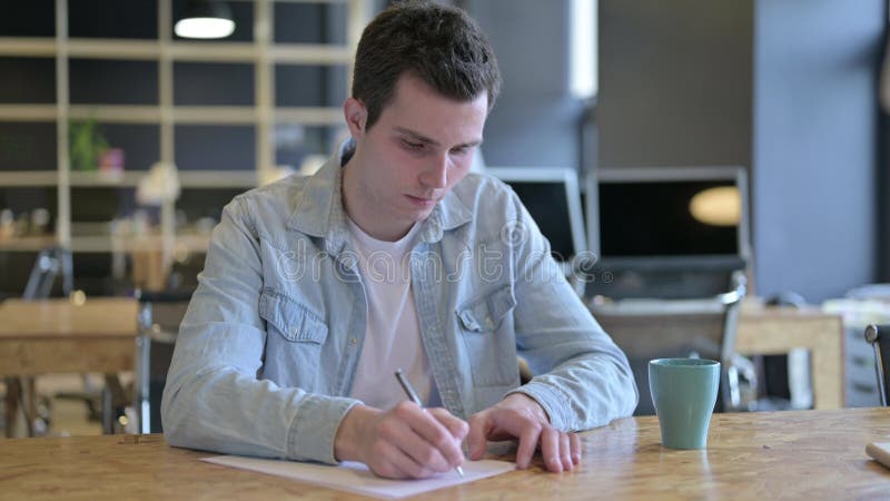 The Focused Young Designer Writing on Paper in Modern Office Stock ...