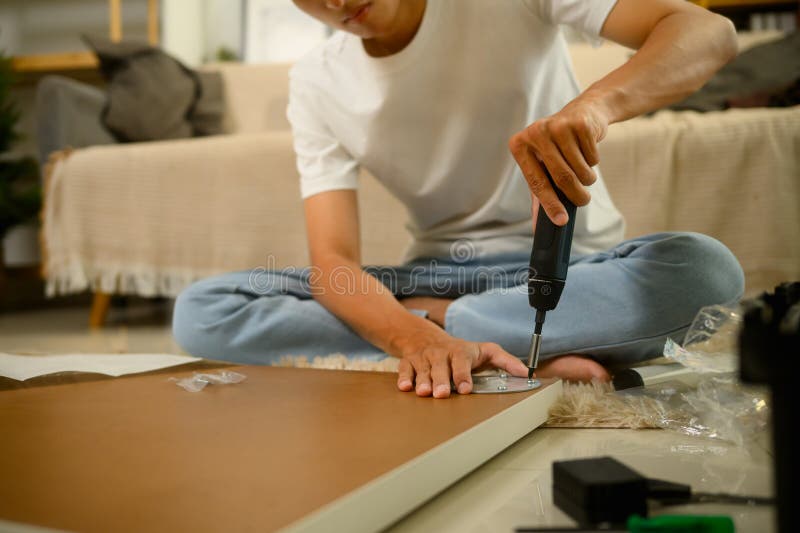 Focused Young Homeowner Assembling a New Table, Using a Drill and Tools ...