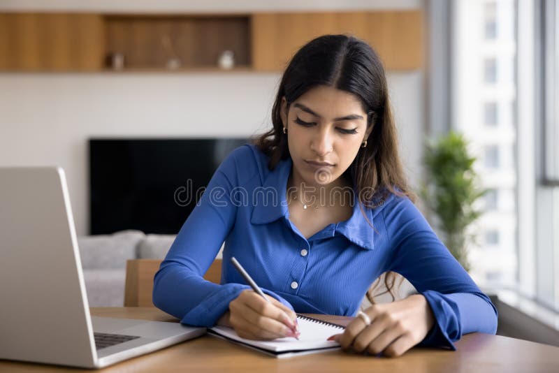 Focused Young Indian Student Girl Writing Notes at Laptop Stock Photo ...
