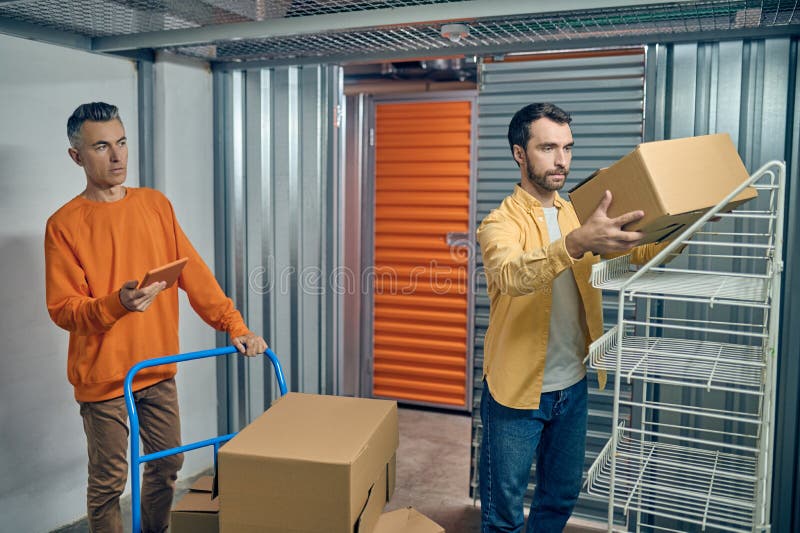 Two Storehouse Employees Unloading Goods in the Storage Room Stock ...