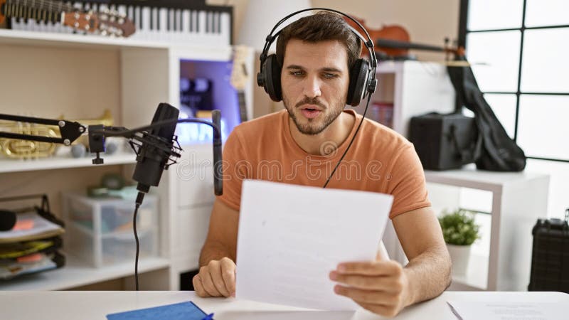 A Focused Young Man in Headphones Reading a Script in a Modern ...