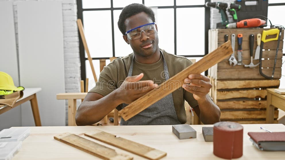 A Focused Young Man Inspects Timber in a Woodwork Studio, Surrounded by ...