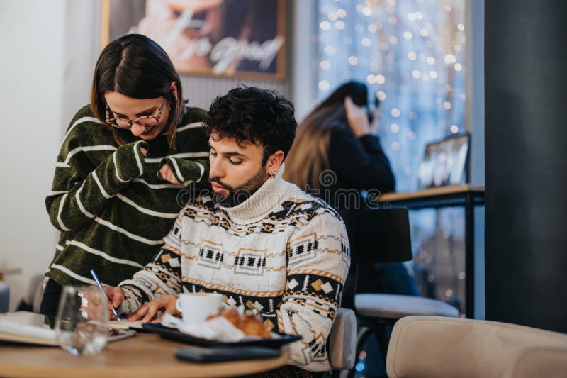 Two Young Adults Engaging in Collaborative Work in a Cafe with Warm ...