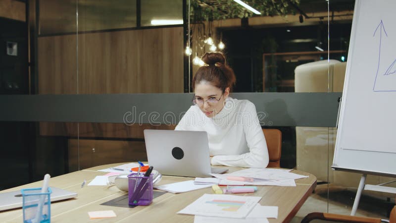 A Focused Young Woman Diligently Working at a Modern Desk, Utilizing a ...