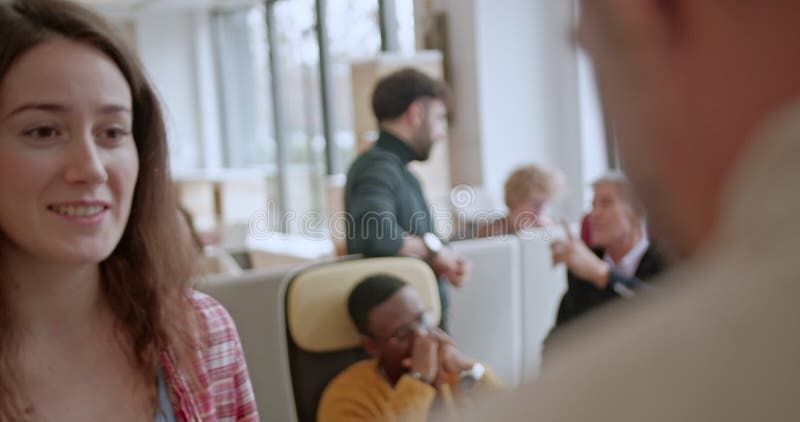 Focused Young Woman Explaining during a Team Discussion in a Brightly ...