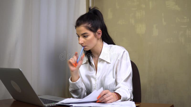 Focused Young Office Worker, Secretary Looking at Laptop Making Notes ...